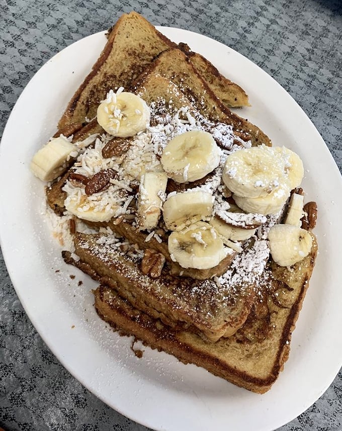 This isn't just French toast—it's a tropical vacation on a plate, where bananas, coconut, and powdered sugar create breakfast paradise.