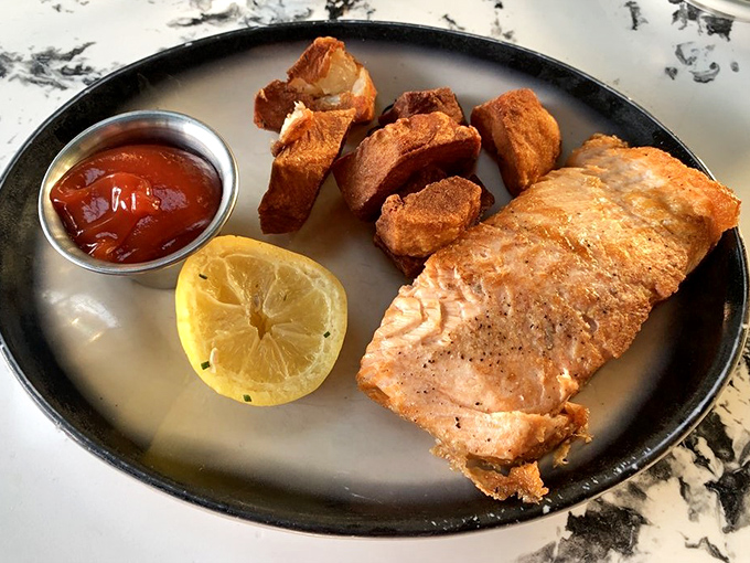 Golden-crusted salmon with crispy potatoes proves The Top isn't just a one-trick pony—they respect the sea as much as the pasture.