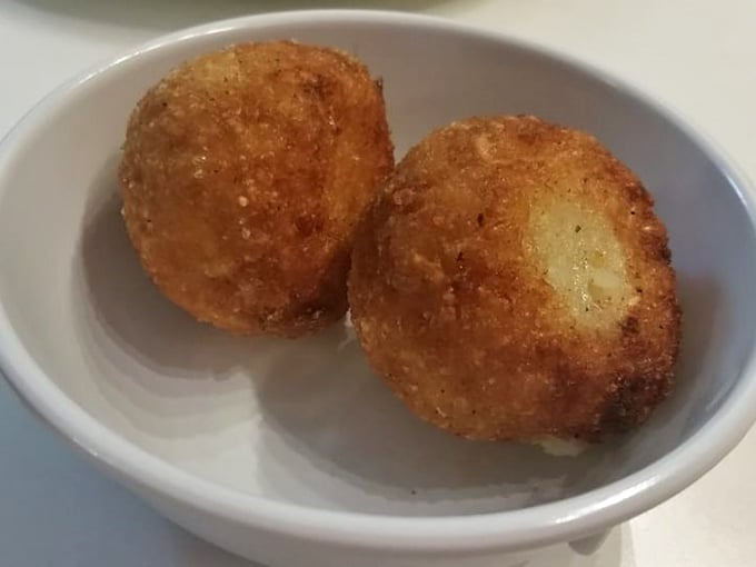 These golden arancini aren't just fried rice balls—they're time machines to Sicilian street corners where comfort food was perfected centuries ago. 