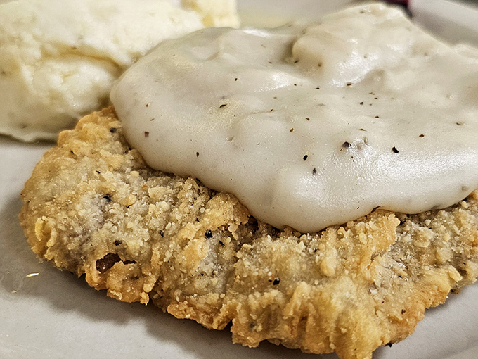 Country-fried steak smothered in peppery gravy alongside green beans and mashed potatoes – the holy trinity of Midwest comfort food.