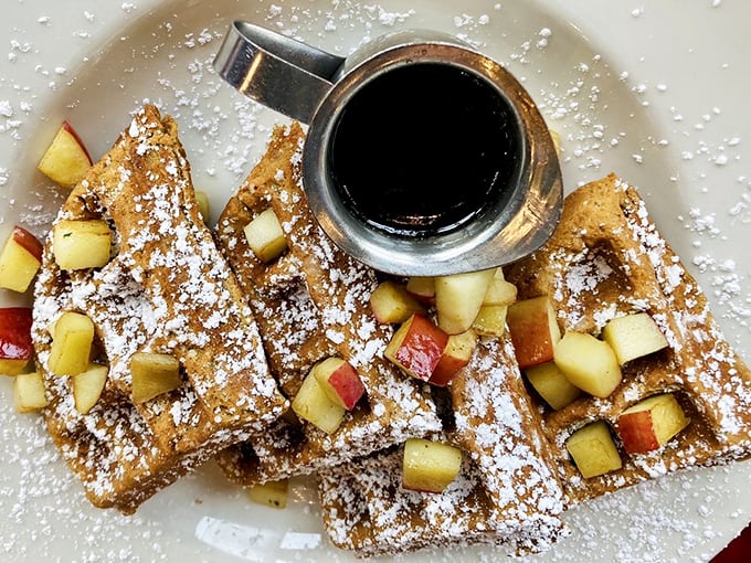 Gingerbread waffles dusted with powdered sugar and topped with fresh apples—breakfast that thinks it's dessert, and nobody's complaining.