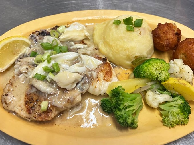 Grouper topped with crab and served alongside fresh vegetables isn't just a meal—it's the reason stretchy pants were invented.