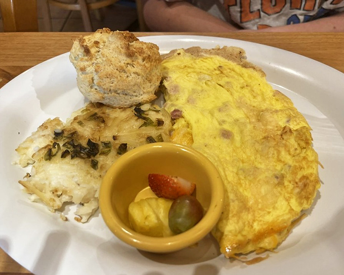 An omelet should be a fluffy cloud cradling treasures within – this golden creation delivers with a side of biscuit that's practically begging for butter.
