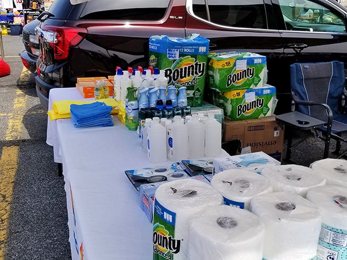 The household essentials table – where smart shoppers stock up on paper towels and cleaning supplies while their spouses hunt for vintage vinyl records.