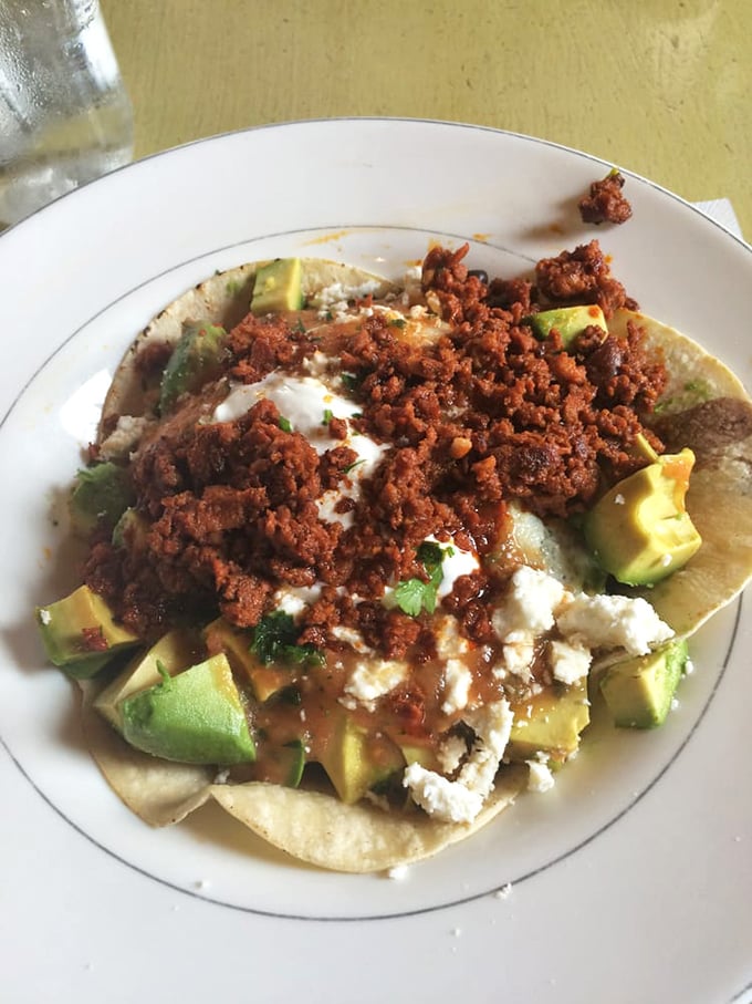 These aren't your average huevos rancheros—they're a fiesta of textures with creamy avocado, crumbled cheese, and chorizo that demands to be savored.