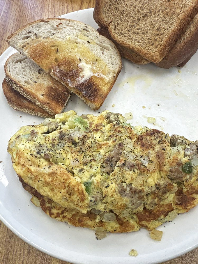 This isn't just an omelet—it's a morning masterpiece. Fluffy eggs wrapped around savory fillings with toast ready for the supporting role.