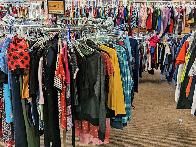 The youth section isn't just clothing—it's potential Halloween costumes, school play outfits, and growth spurt solutions all hanging in harmonious chaos.
