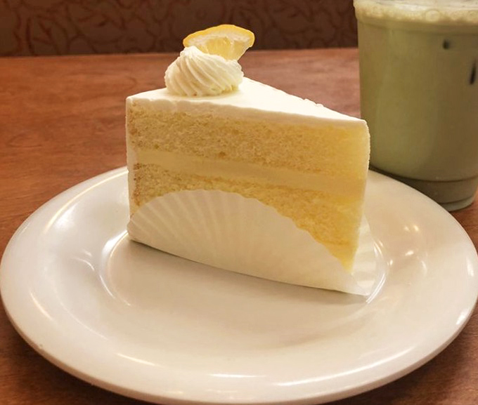 A slice of lemon cake so pristine it belongs in the Museum of Perfect Desserts. Light, bright, and absolutely divine.