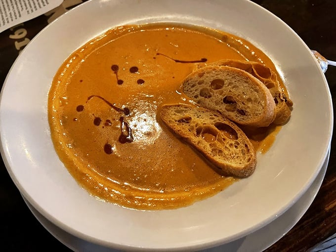 This lobster bisque arrives looking like liquid luxury, topped with herbs that know their supporting role.