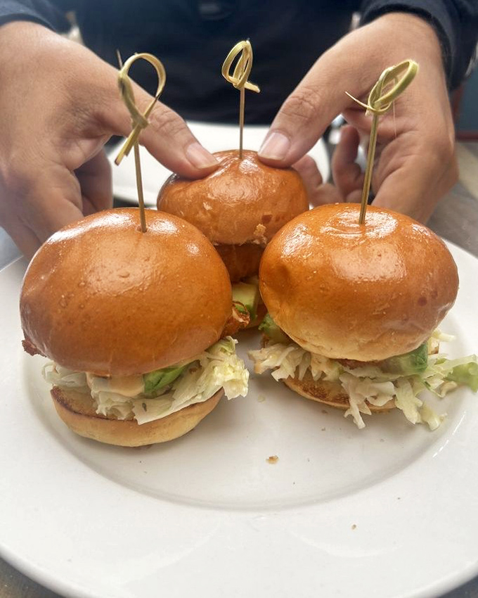 These mahi sliders aren't just appetizers; they're three perfect bites of ocean-fresh goodness topped with crisp slaw on pillowy brioche buns.