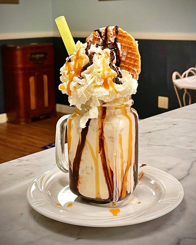 Not so much a milkshake as an architectural achievement – chocolate, caramel, and a waffle garnish creating a tower of dairy decadence.