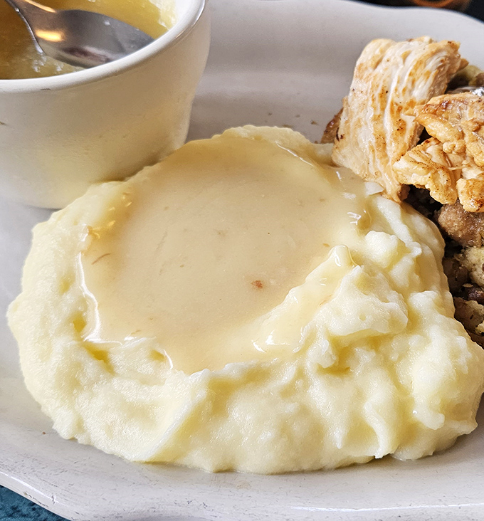 These mashed potatoes aren't whipped into submission by some fancy machine—they're hand-mashed mountains of buttery comfort waiting to cradle that gravy.
