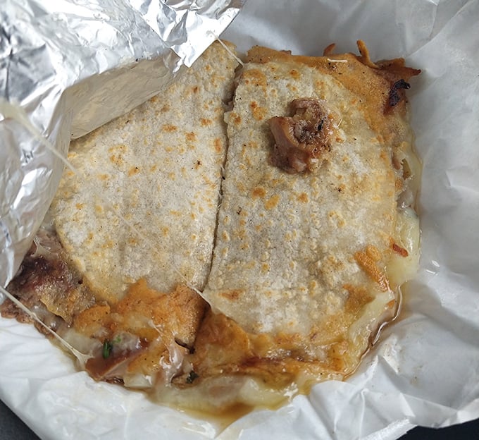 The mulita de mixta: where cheese meets meat in tortilla-bound matrimony. Two corn tortillas embracing carnitas and cheese—a sandwich that makes bread seem unnecessary.