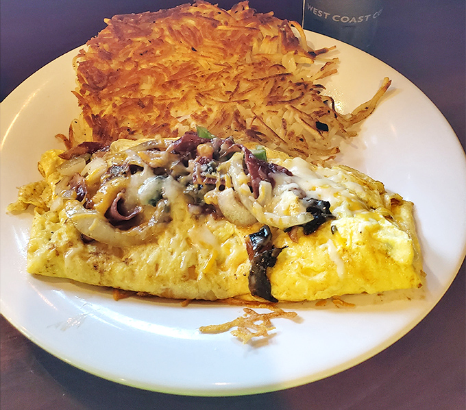 An omelet that doesn't know the meaning of restraint, paired with hash browns crisped to golden perfection. Morning glory on a plate.