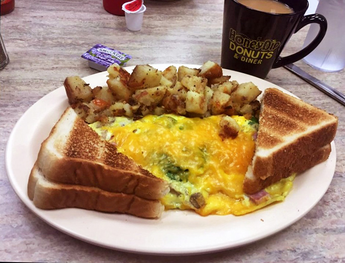 Behold the Western omelet in its natural habitat—fluffy, generous, and surrounded by perfectly seasoned home fries. Breakfast doesn't get more honest than this.