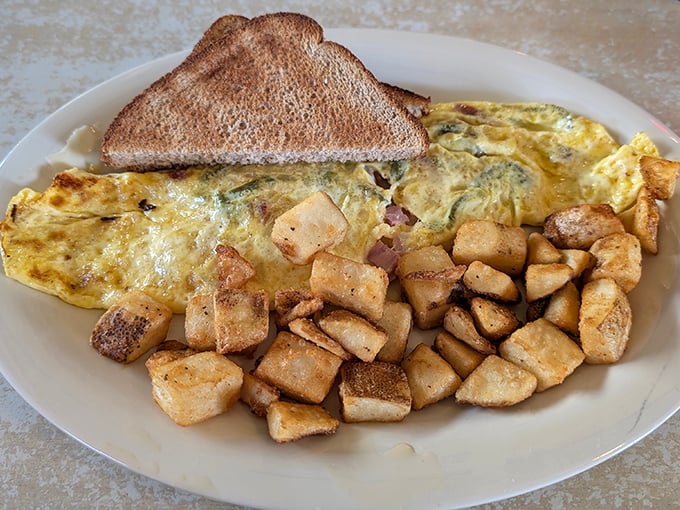 This omelet doesn't just whisper "good morning"—it belts it out like Ethel Merman, with home fries crisped to golden perfection on the side.
