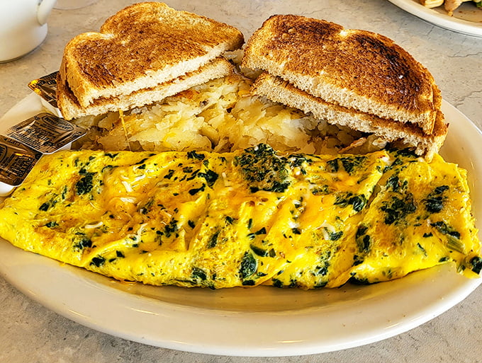 This spinach and cheese omelet doesn't just whisper "good morning"—it belts it out like Sinatra, with perfectly toasted bread as backup singers.