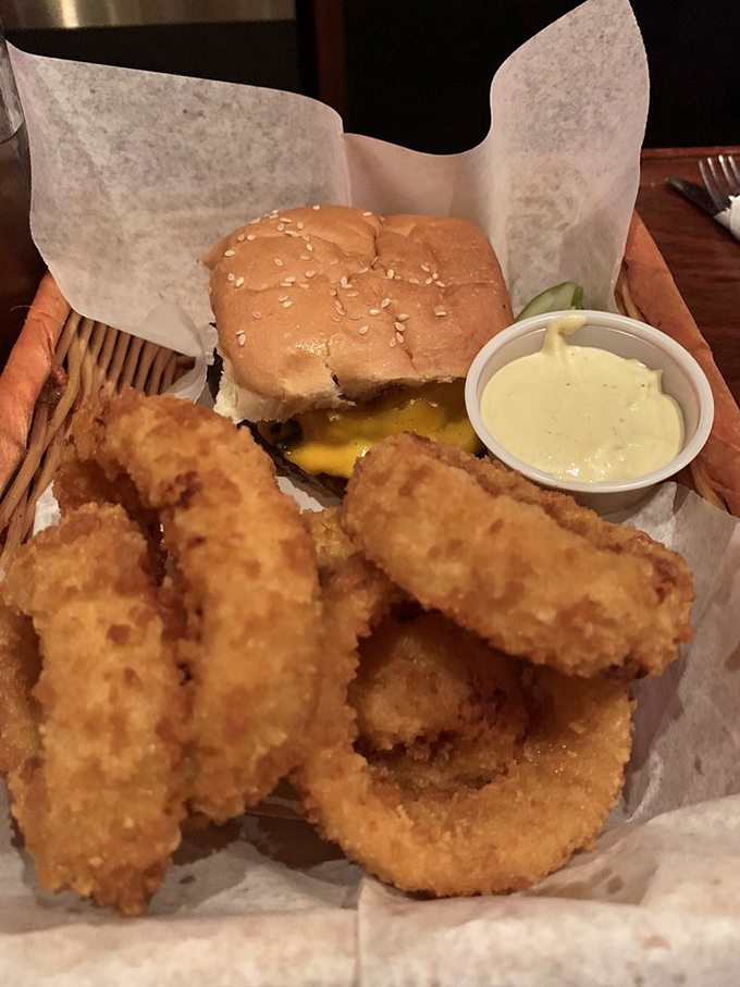 Golden rings of joy nestled beside a perfectly crafted burger—proof that sometimes the supporting actors steal the show. 