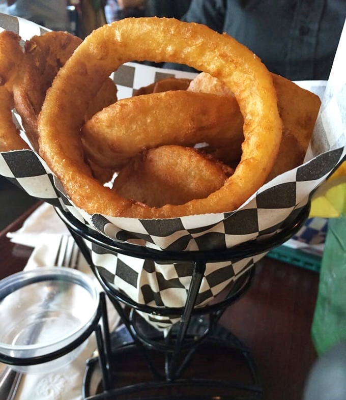 Onion rings that achieve the perfect crunch-to-tenderness ratio. The checkered paper says "casual," but the execution screams "we take our fried foods seriously."