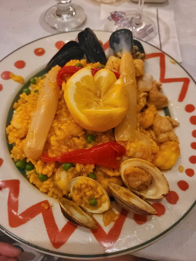 Paella Valenciana arrives like a saffron-hued celebration on a plate—seafood, chicken and vegetables creating a Spanish symphony that would make even paella purists swoon.