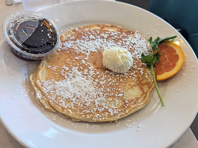 This pancake doesn't just arrive at your table—it makes an entrance. Dusted with powdered sugar and topped with butter that melts like your resolve.