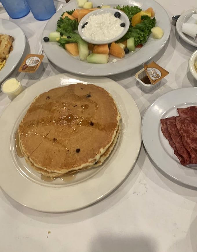 Golden pancakes that could double as edible frisbees share table space with fresh fruit – breakfast nirvana has been achieved.