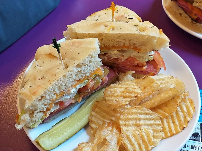 This sandwich isn't just lunch—it's architecture. Layers of goodness stacked between house-made focaccia with the obligatory pickle and chips sidekicks.