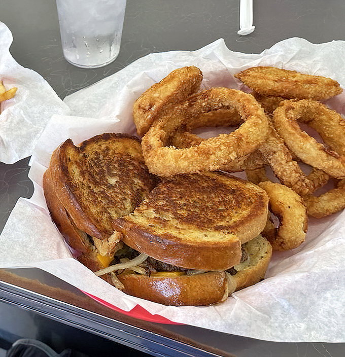 Grilled cheese perfection meets golden onion rings – a combo that would make both your cardiologist and inner child have strong opinions.