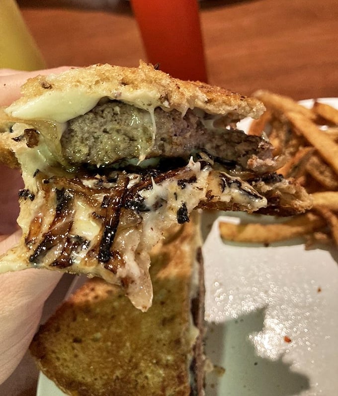 The patty melt in mid-bite glory—where melted cheese meets caramelized onions in a symphony that makes the long drive worthwhile.