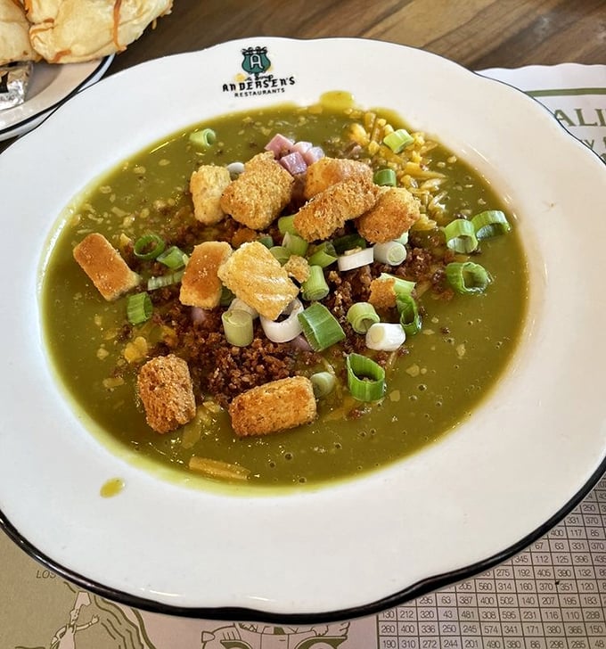 The famous split pea soup, adorned with croutons, bacon bits, and green onions—a verdant bowl of comfort that's converted generations of skeptics.