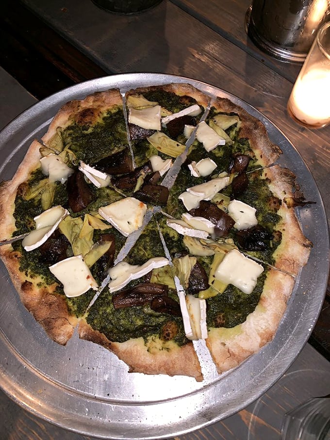 This isn't just pizza—it's a garden party on a crust, where pesto plays host and artichokes mingle with perfectly melted cheese.