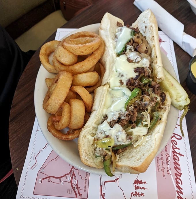 This isn't just a Philly cheesesteak—it's a masterclass in sandwich architecture, with perfectly melted cheese cascading over seasoned beef. Those onion rings deserve their own zip code.