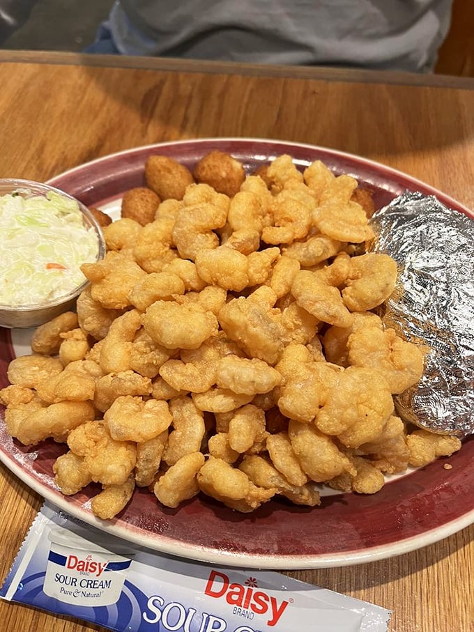 Golden-fried popcorn shrimp piled high like delicious treasure—proof that sometimes the best seafood comes in small, crispy packages.