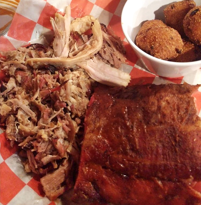 Barbecue nirvana on a red-checkered plate. The pulled pork's smoke ring is like nature's way of saying "you're welcome."