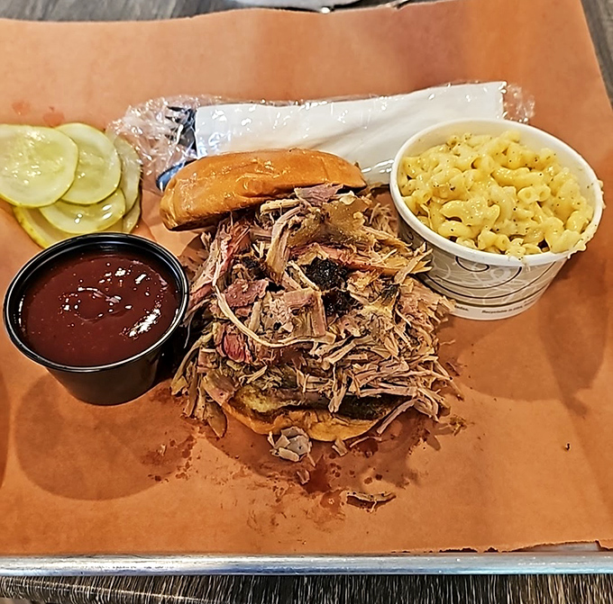 This pulled pork sandwich isn't just a meal, it's an architectural marvel of smoke-kissed meat, pickles, and that essential side of mac and cheese.