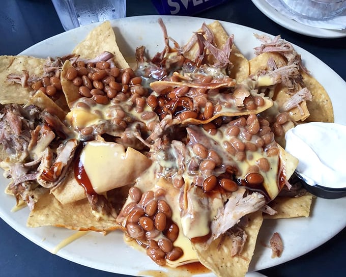These pulled pork nachos aren't messing around—a mountain of beans, cheese, and BBQ that requires a strategy session before the first delicious bite.