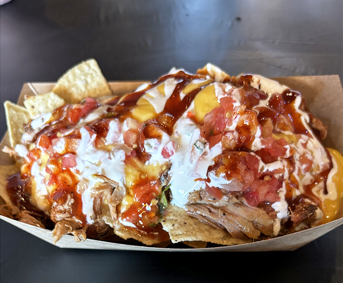 Behold the pulled pork nachos—where tortilla chips fulfill their destiny as vehicles for smoky meat, melty cheese, and tangy sauce.