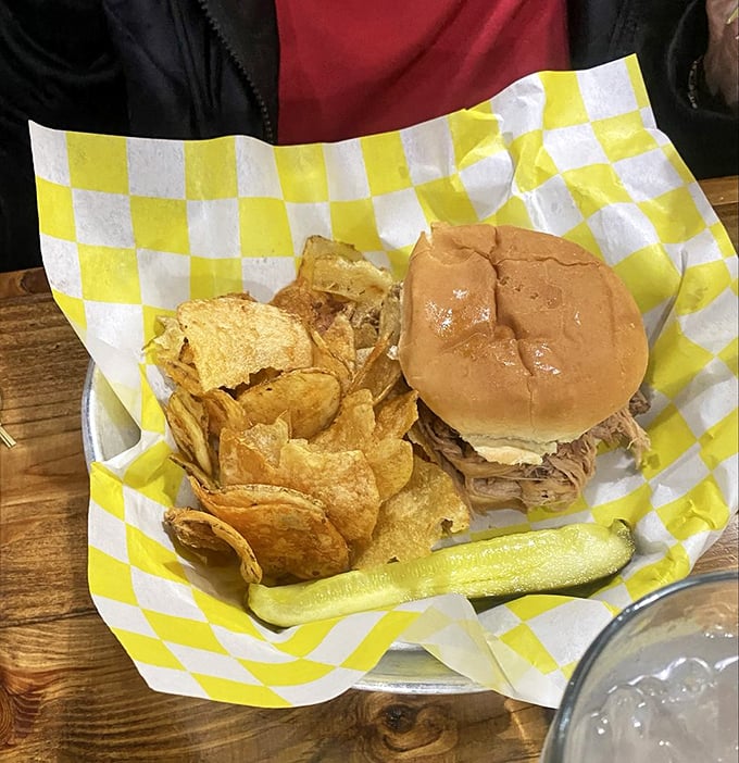 A proper pulled pork sandwich doesn't need fancy frills—just house-made chips, a pickle spear, and meat that speaks for itself.