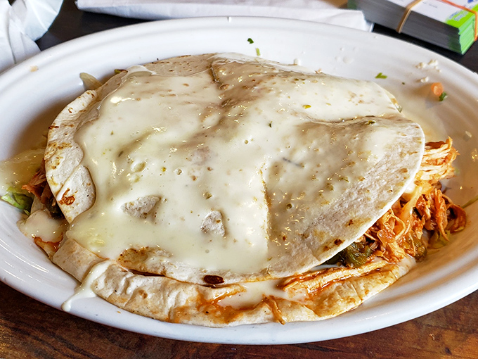 This quesadilla isn't just melted cheese between tortillas—it's a warm, gooey hug on a plate, blanketed in queso that means business.