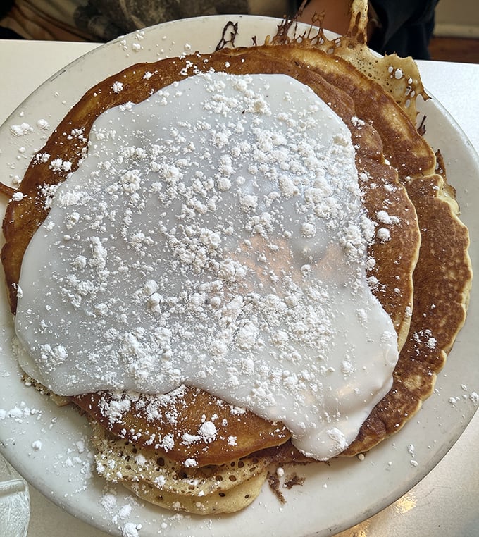 These pancakes aren't just topped with powdered sugar—they're wearing a delicate snow-white gown for their grand entrance to your table.