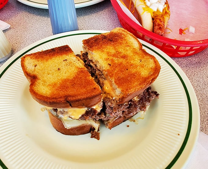 Not just a Reuben burger, but a declaration of deliciousness—toasted bread hugging seasoned beef, melty cheese, and tangy sauerkraut in a sandwich that demands to be photographed before devoured.