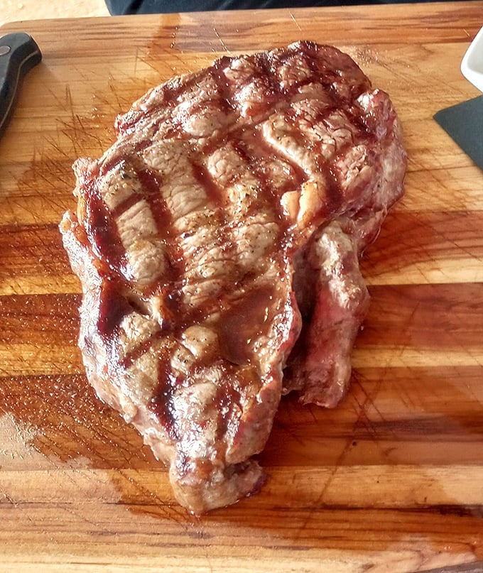 A ribeye with grill marks so perfect they could teach geometry. This isn't just steak—it's meat architecture with a PhD in flavor.