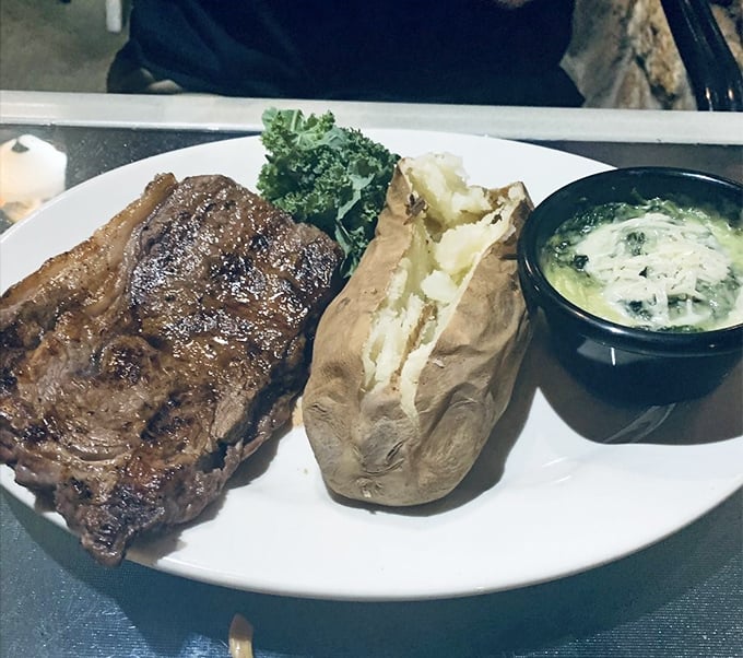 The ribeye doesn't just sit on the plate—it commands attention like a Broadway star on opening night, with a supporting cast of potato and creamed spinach.