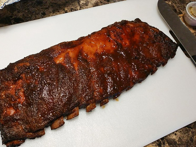 These ribs have the kind of bark that makes tree trunks jealous. The glossy finish isn't vanity—it's a testament to hours in the smoker.
