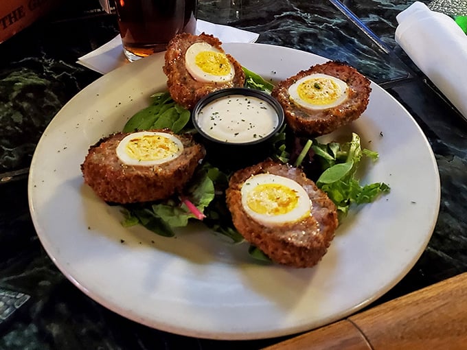 Scotch eggs done right – crispy exterior giving way to savory sausage and that perfect soft-boiled center. Pub food elevated beyond bar snack to culinary art form.