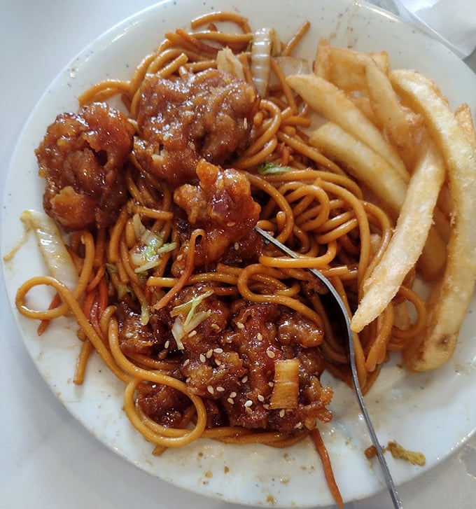 Lo mein noodles tangled with sesame chicken and fries—the buffet equivalent of "why choose when you can have it all?"