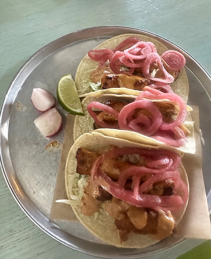 Fish tacos topped with vibrant pink pickled onions—proof that sometimes the most beautiful things in life come on corn tortillas.