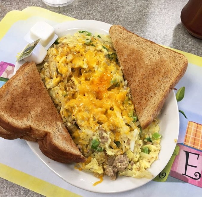 Breakfast alchemy at its finest: eggs, cheese, and meat dancing together in perfect harmony, flanked by toast soldiers ready for dipping duty.