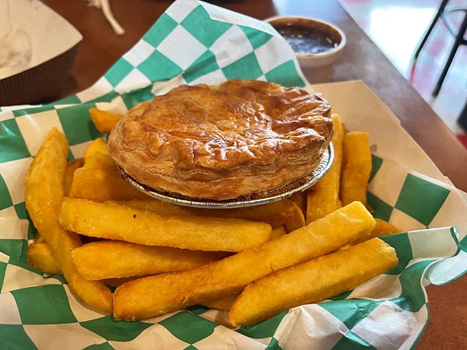 A proper savory pie surrounded by golden chips—the kind of hearty meal that makes you want to cheer for a team you've never heard of.