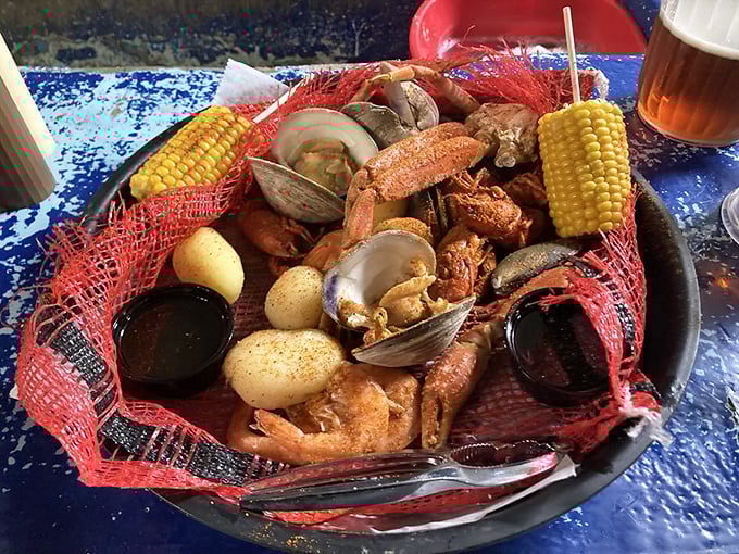 The seafood platter arrives like a fisherman's dream—clams, corn, potatoes, and shrimp nestled in a red net of deliciousness.